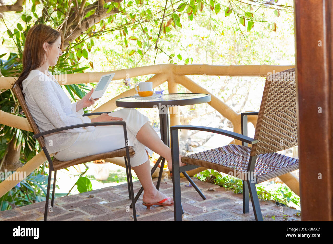 woman reading e-book on balcony Stock Photo - Alamy