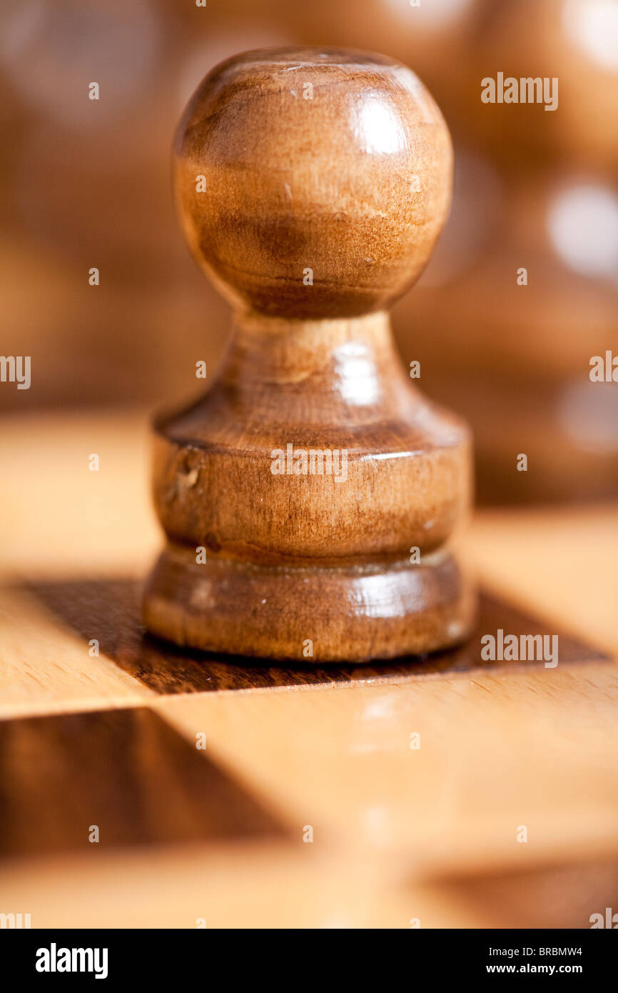 Pawn in front of chess pieces on a board, shallow depth of field Stock ...