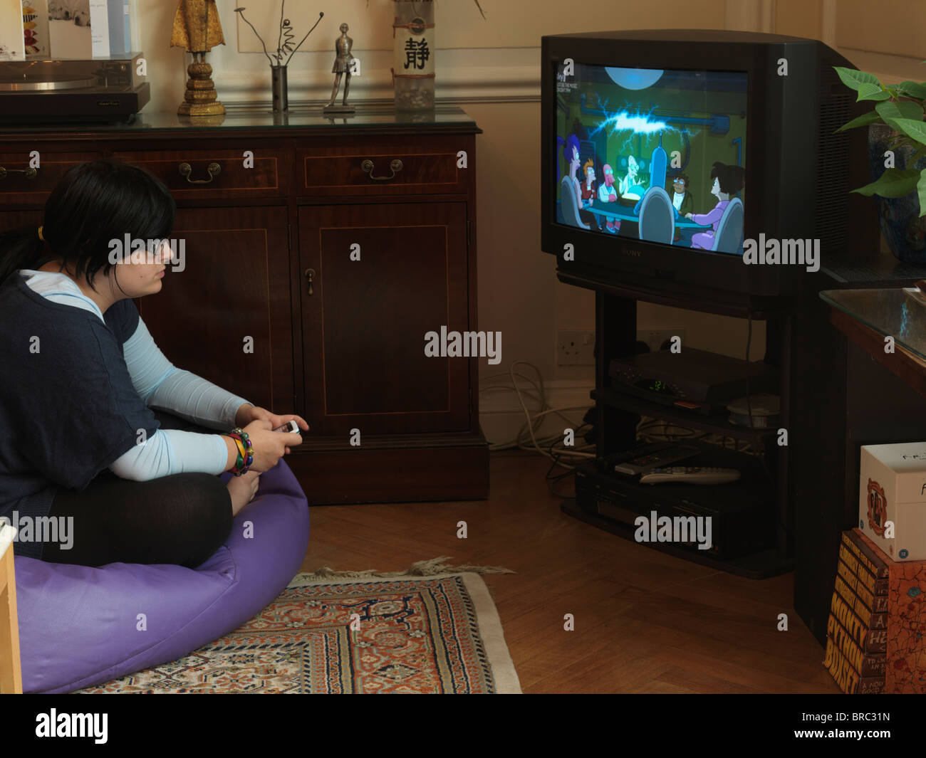 A Teenage Girl Texting on a Mobile Phone While Watching Television ...