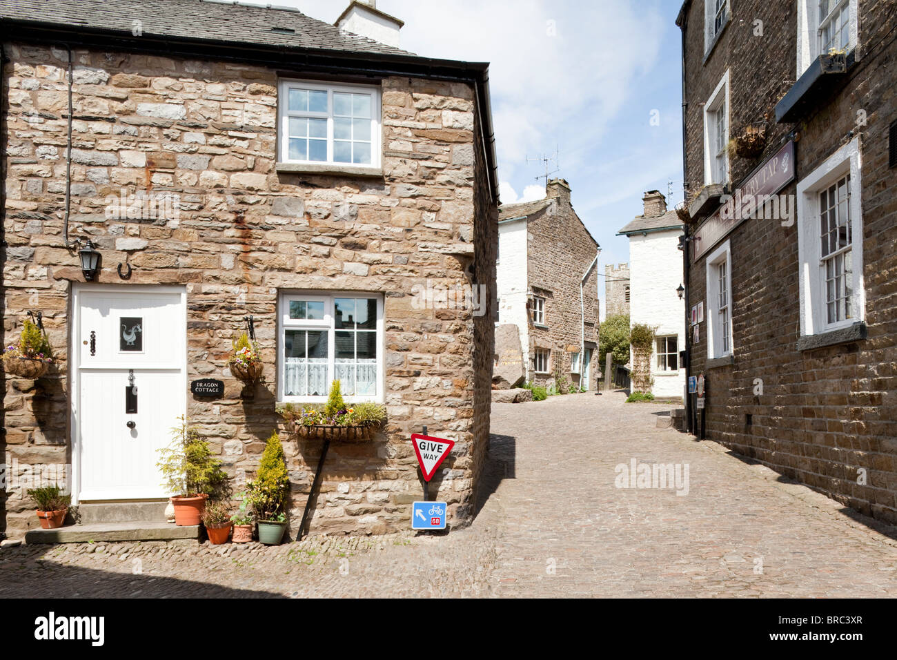The cobbled Main Street of the Yorkshire Dales National Park village of ...