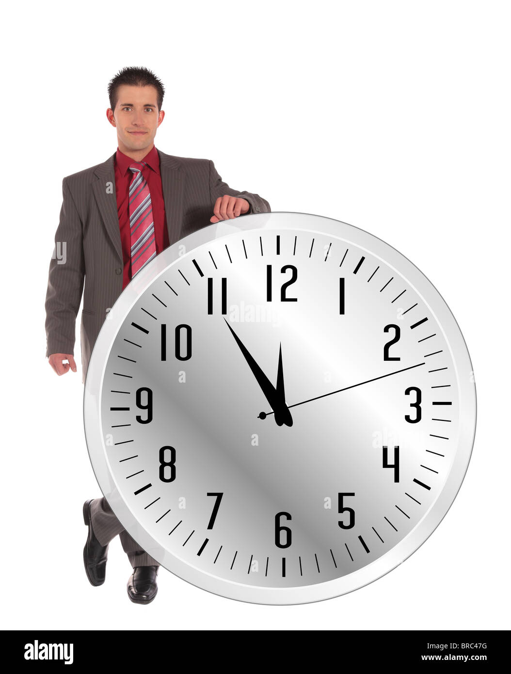 A handsome businessman standing next to a huge clock that shows the ...
