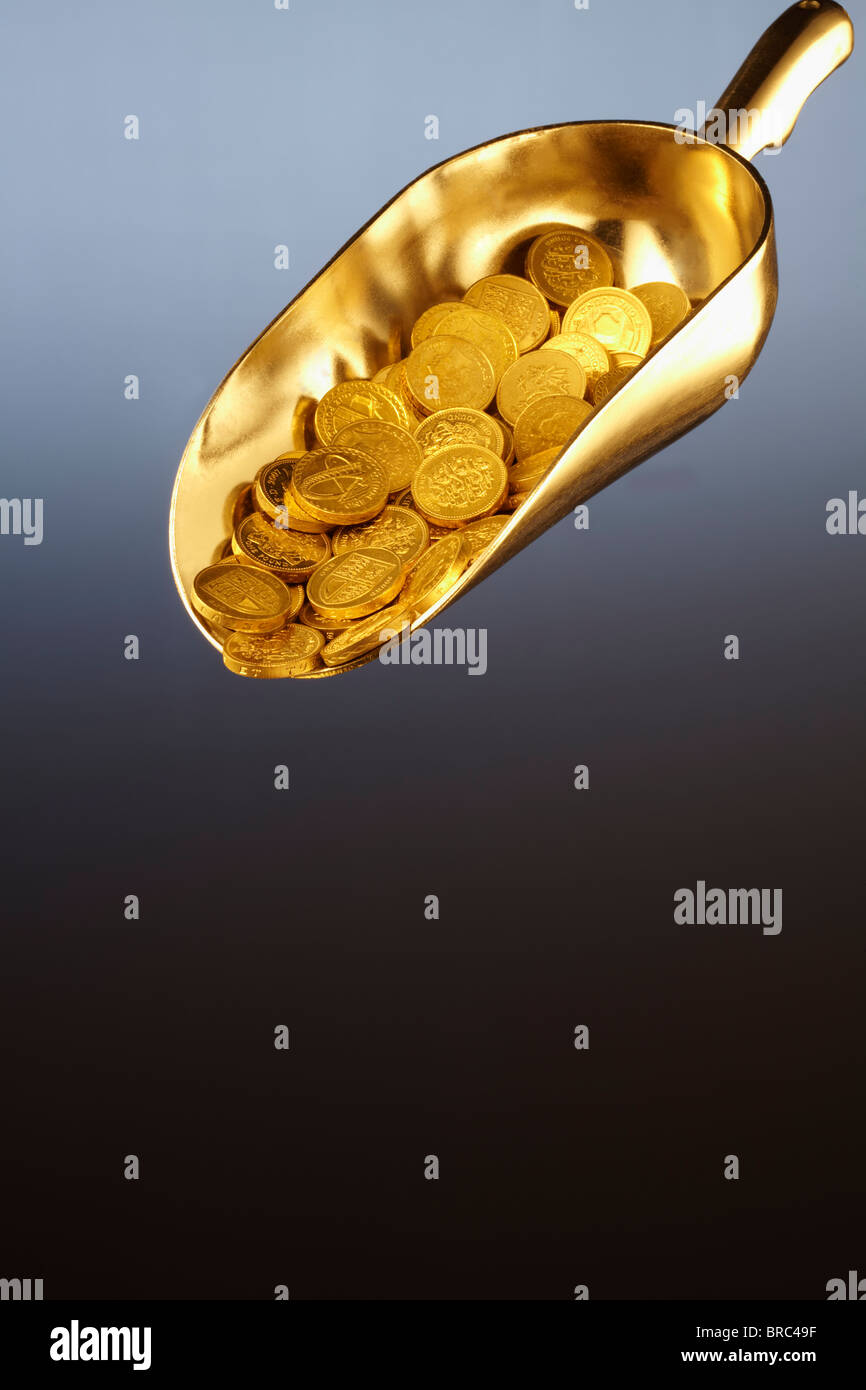 Golden scoop of money Stock Photo - Alamy