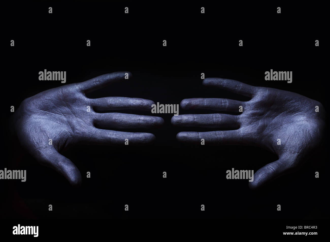 beautiful man's hands in silver paint on a black background Stock Photo ...