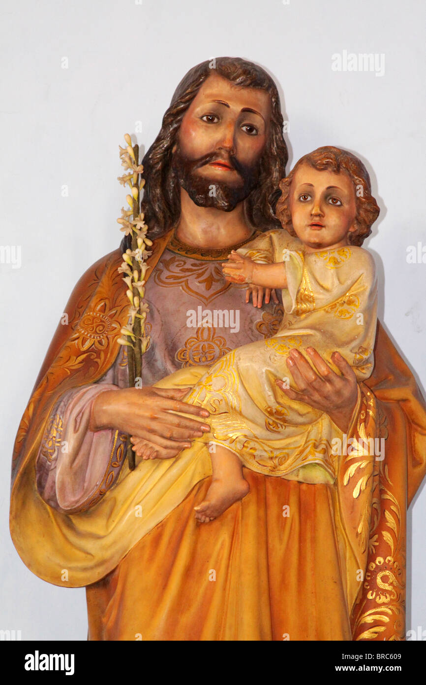 Saint Joseph (San Jose) carrying a Jesus Christ boy statue at an altar ...
