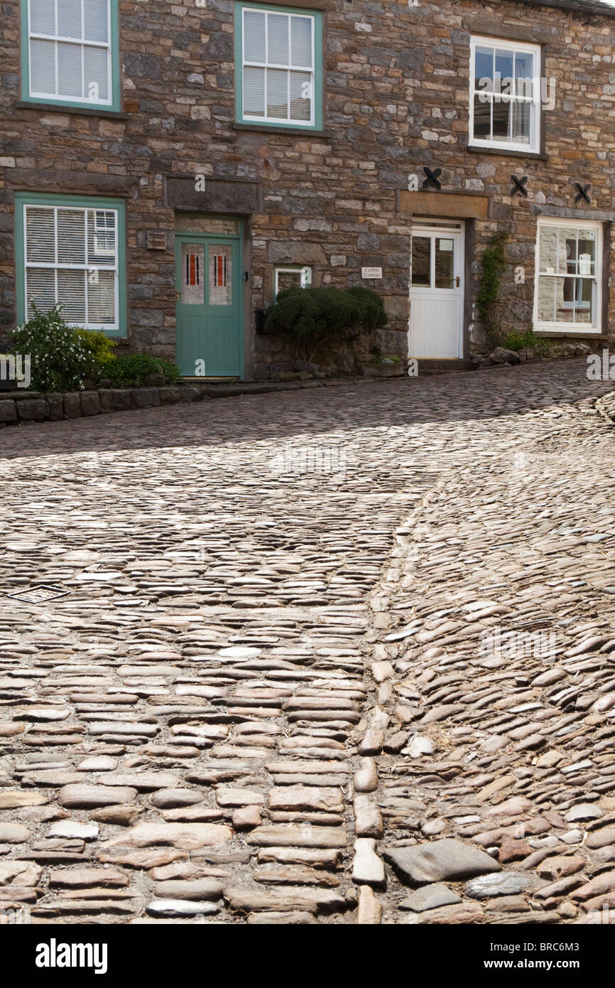 The cobbled Main Street of the Yorkshire Dales National Park village of ...