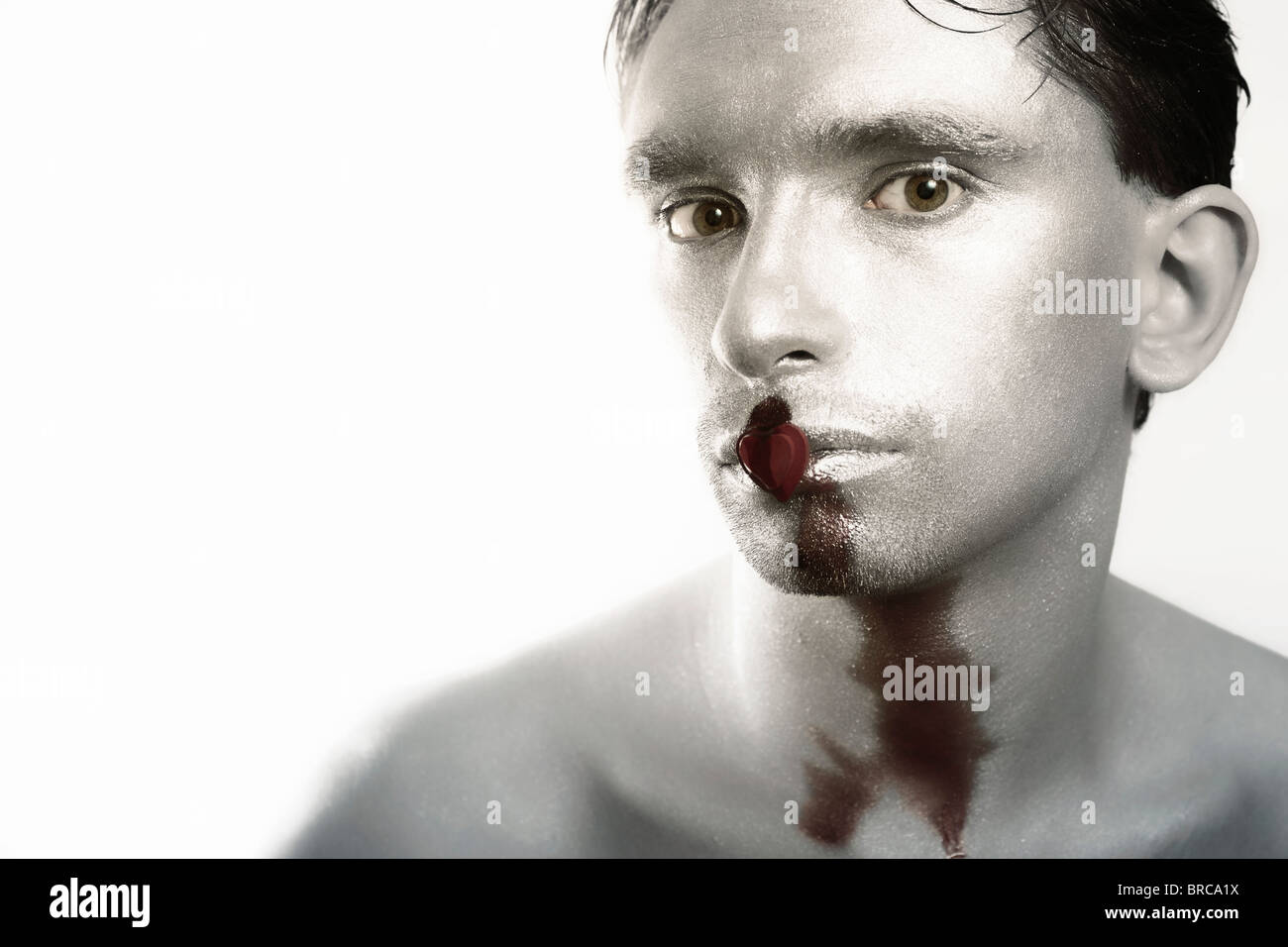 young man with silver makeup and bleeding hearts in mouth Stock Photo ...
