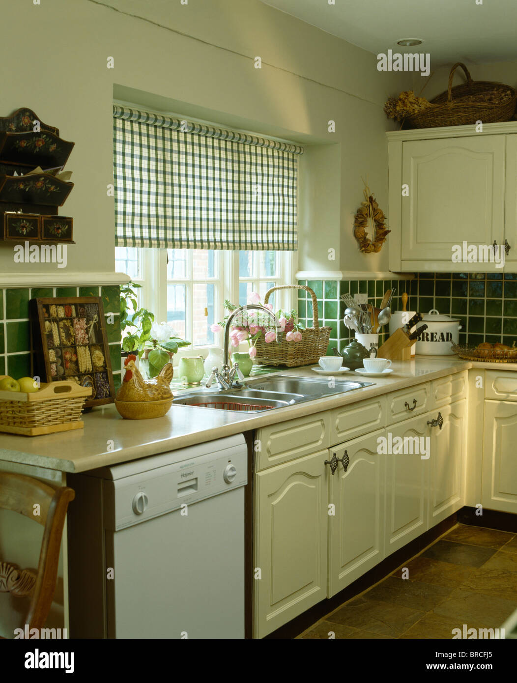 Green checked blind on window above sink in white cottage kitchen with ...