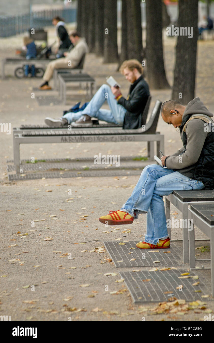 People sitting on benches in park Stock Photo - Alamy