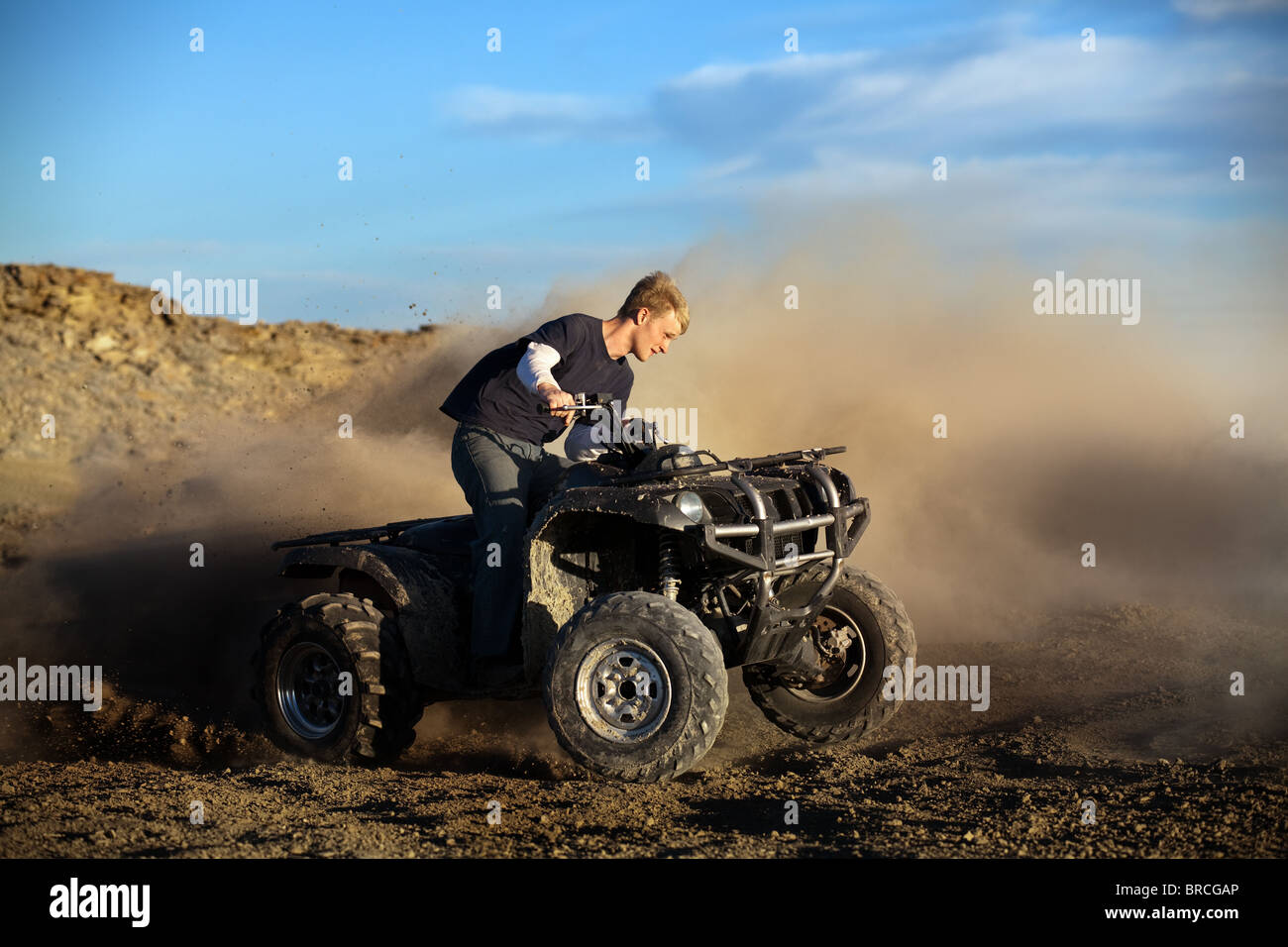 Teen male riding quad / four-wheeler 4x4 on the dirt Stock Photo - Alamy