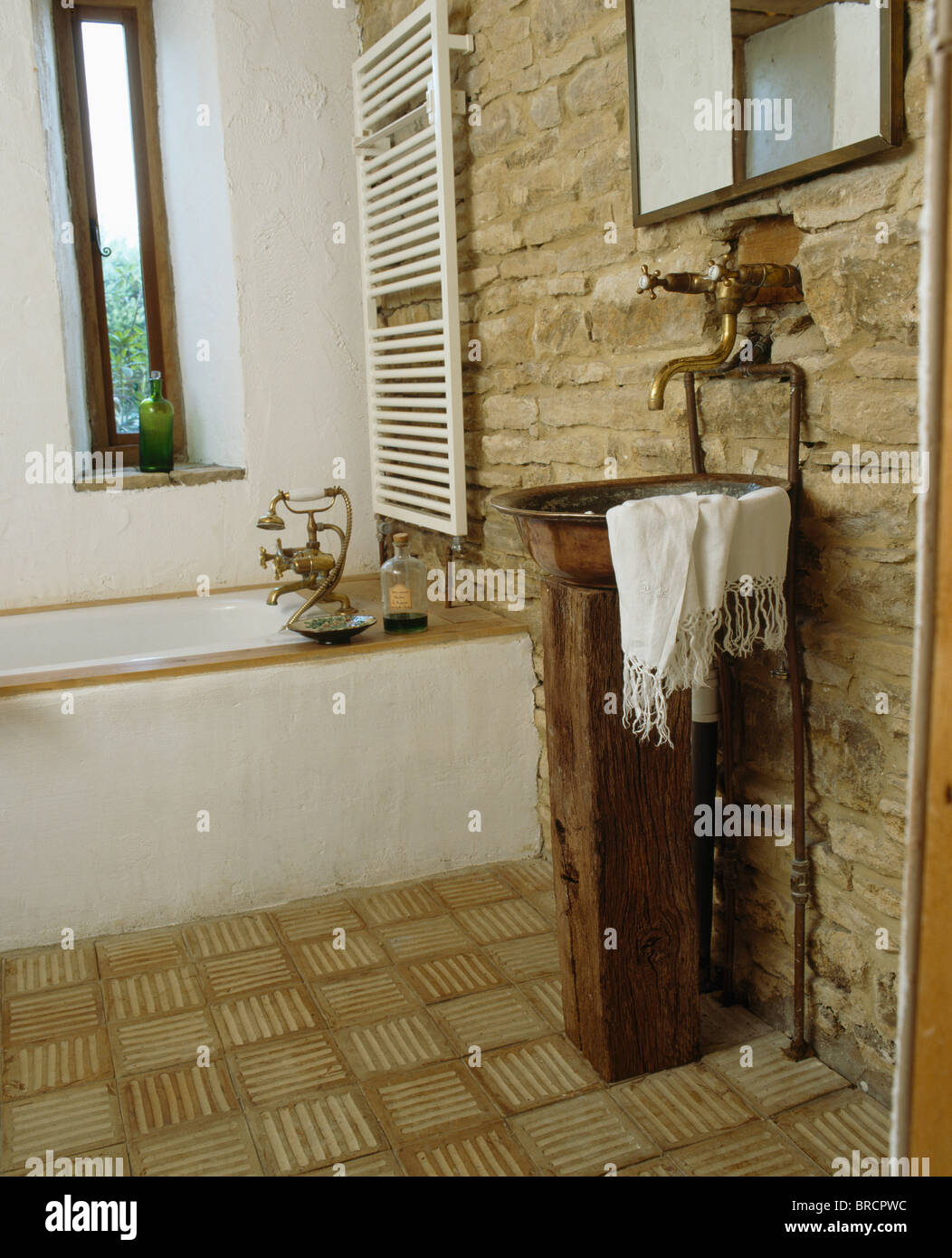 Copper basin on pedestal in barn conversion bathroom with exposed stone ...