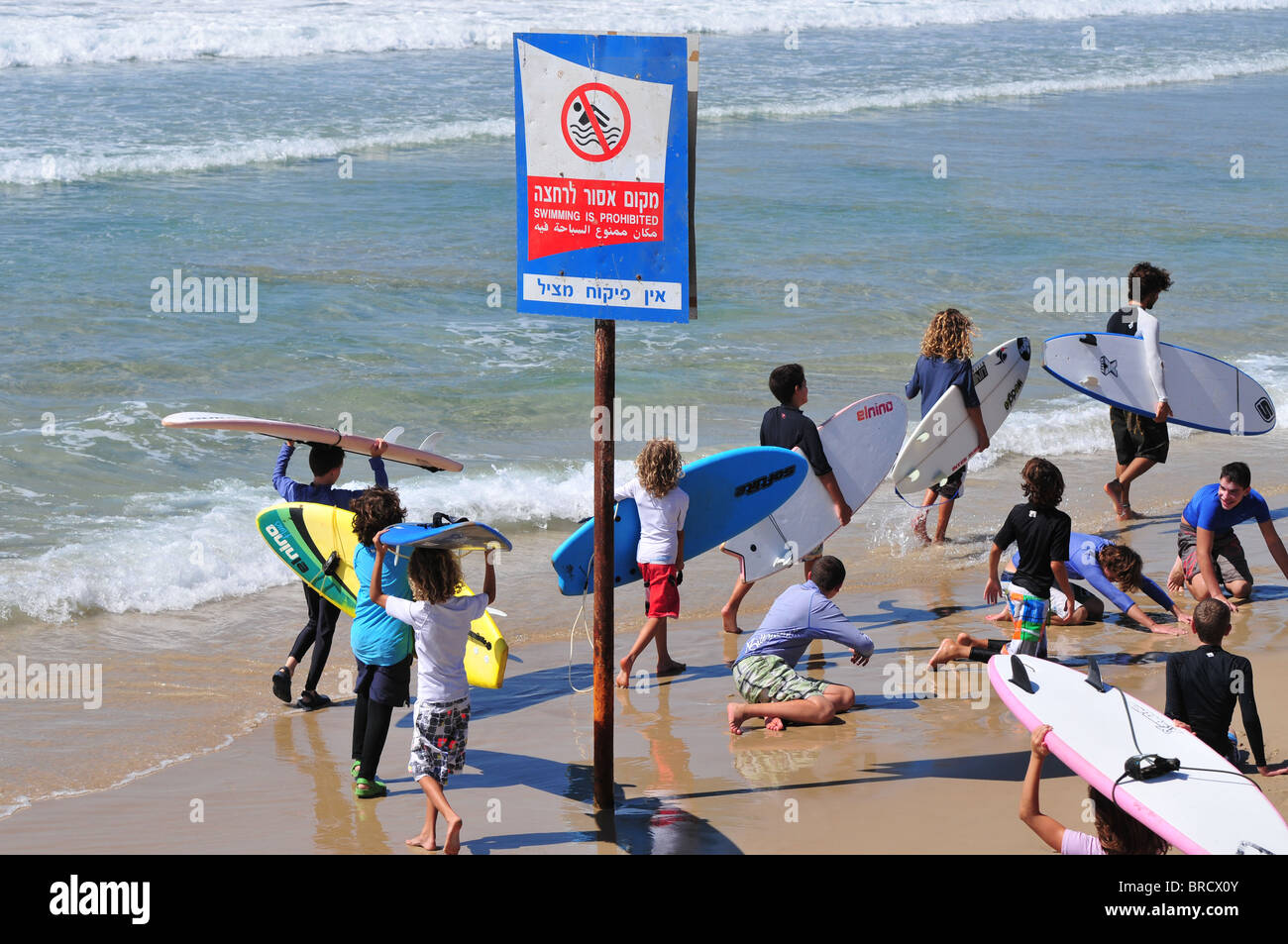 Israel, Haifa, summer activity on the beach Surfers enter the water ...