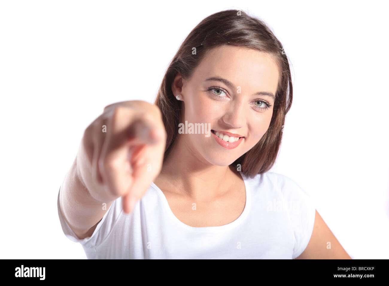 An attractive young woman pointing at someone. All isolated on white ...