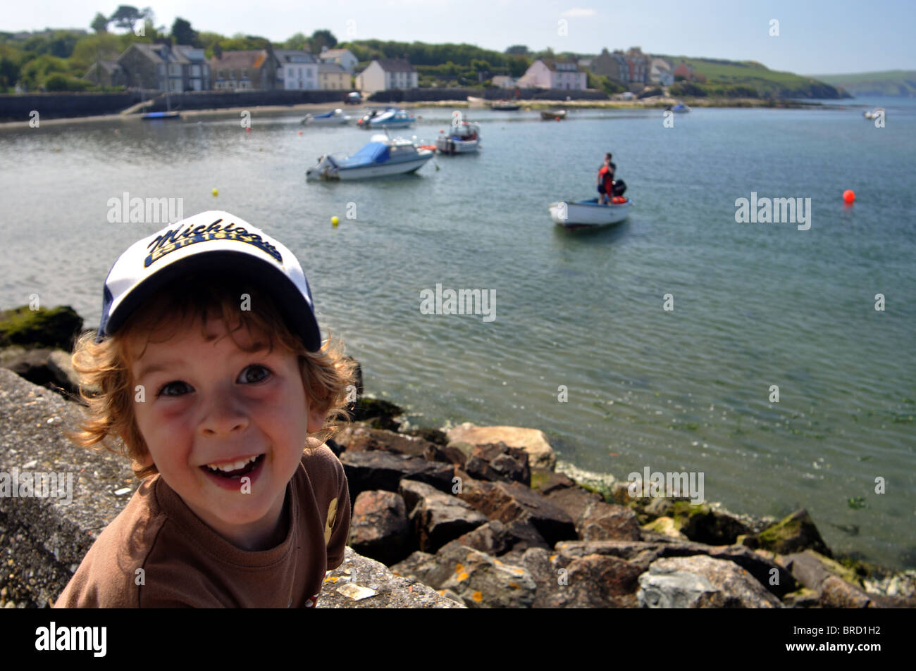 Young boy smiling at seaside, Parrog beach, Newport, Pembrokeshire ...