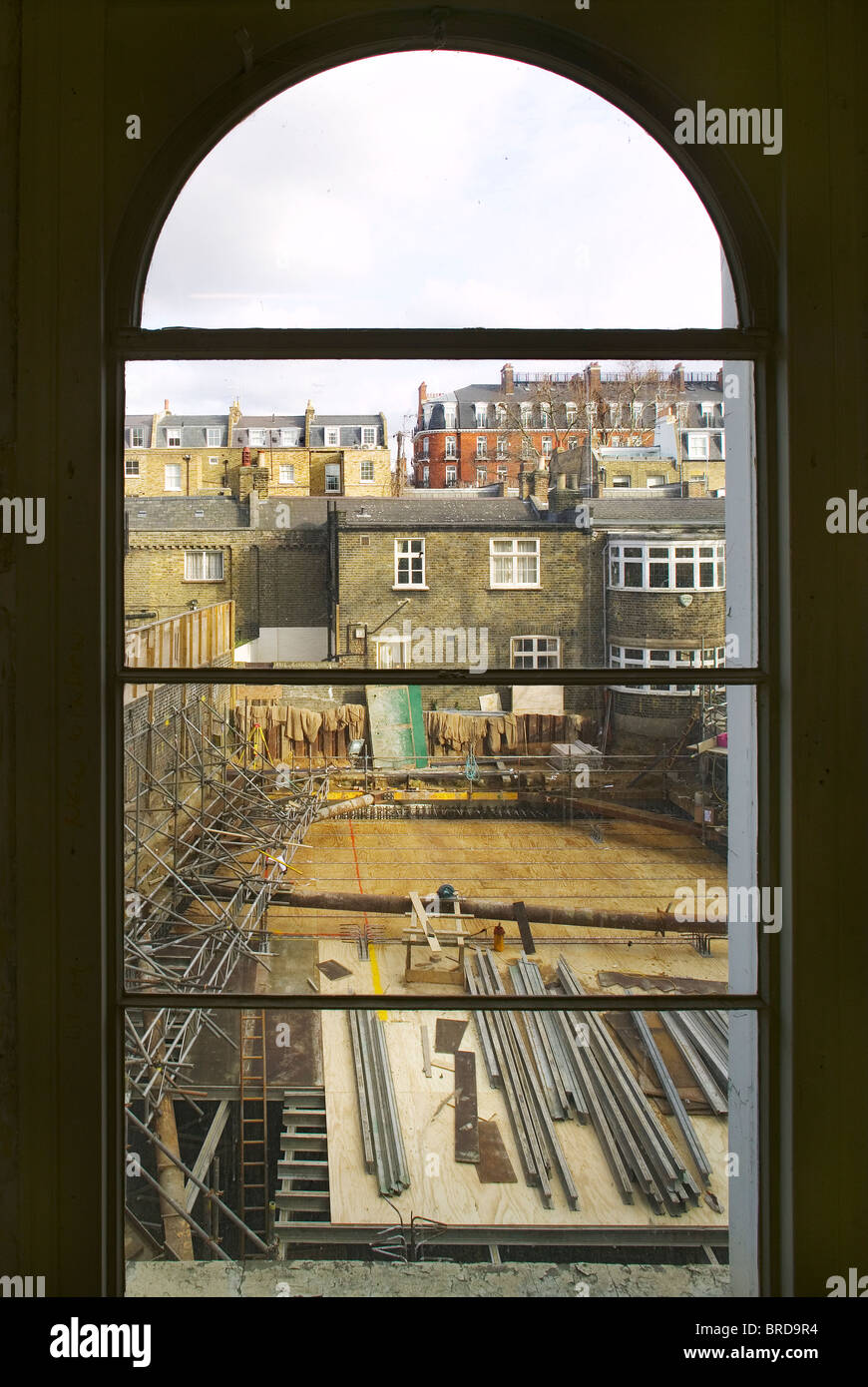 View through arched window to building site Stock Photo - Alamy