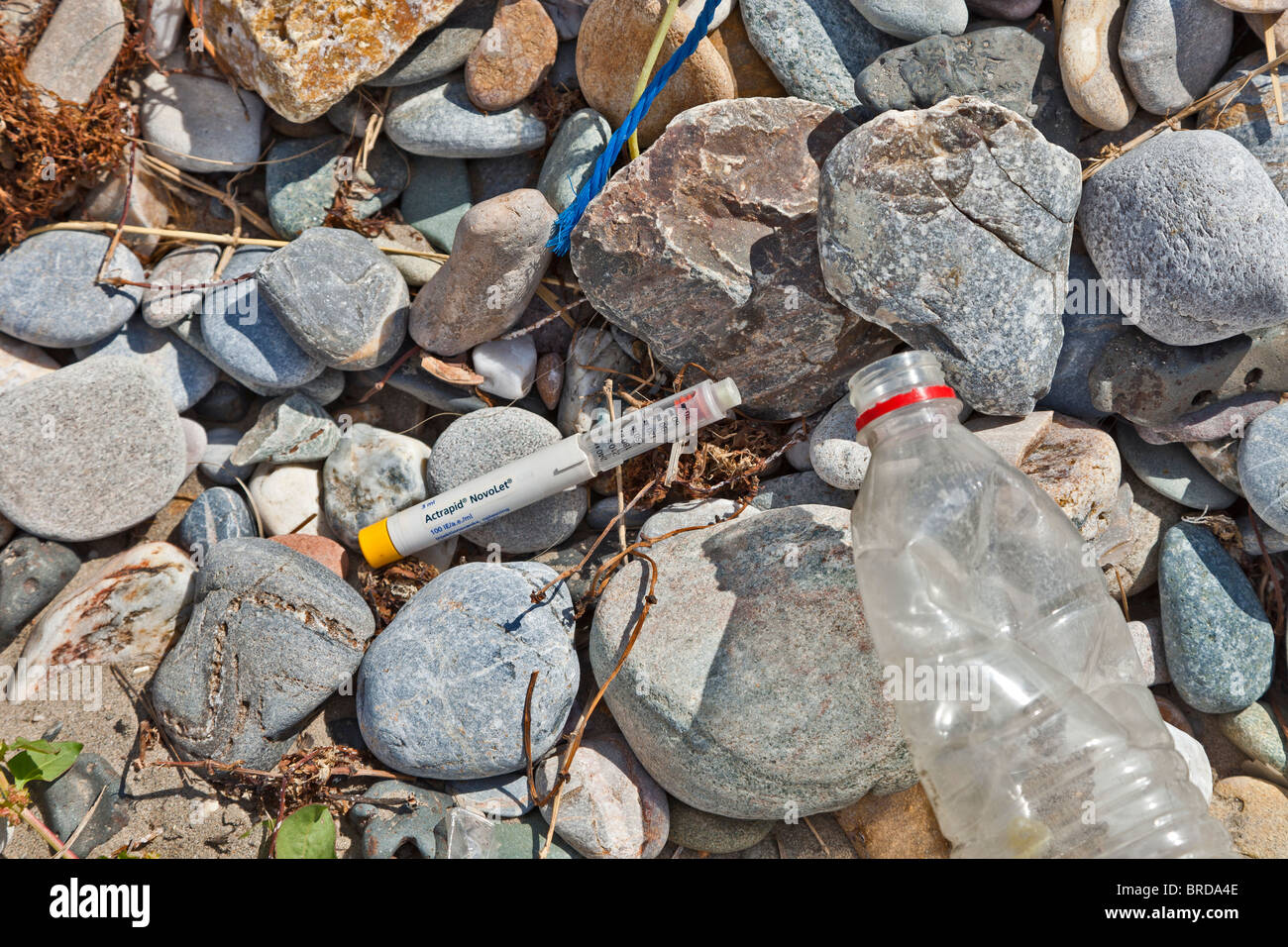 Discarded insulin syringe on beach with other debris Stock Photo - Alamy