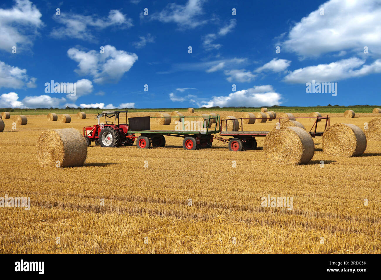 A wide open field showing some bales of straw Stock Photo - Alamy