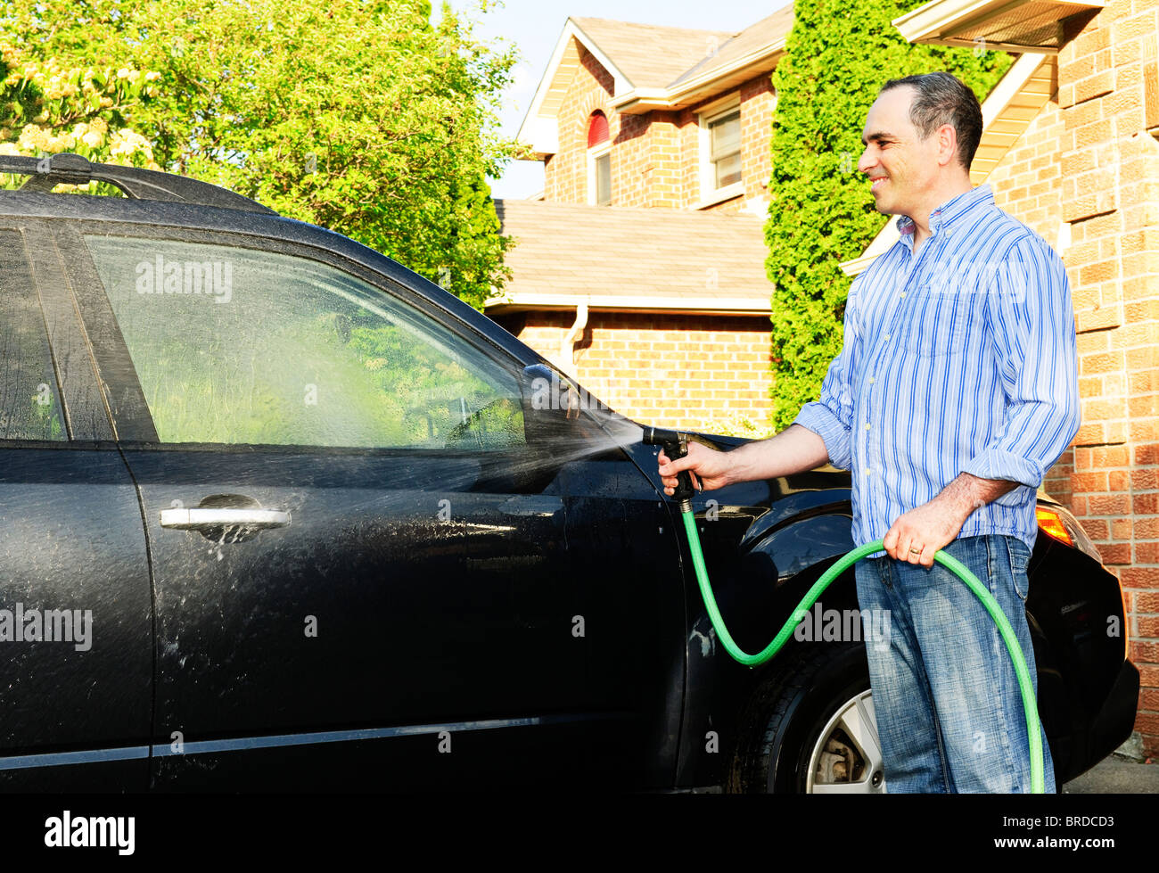 Man washing his car on the driveway Stock Photo - Alamy