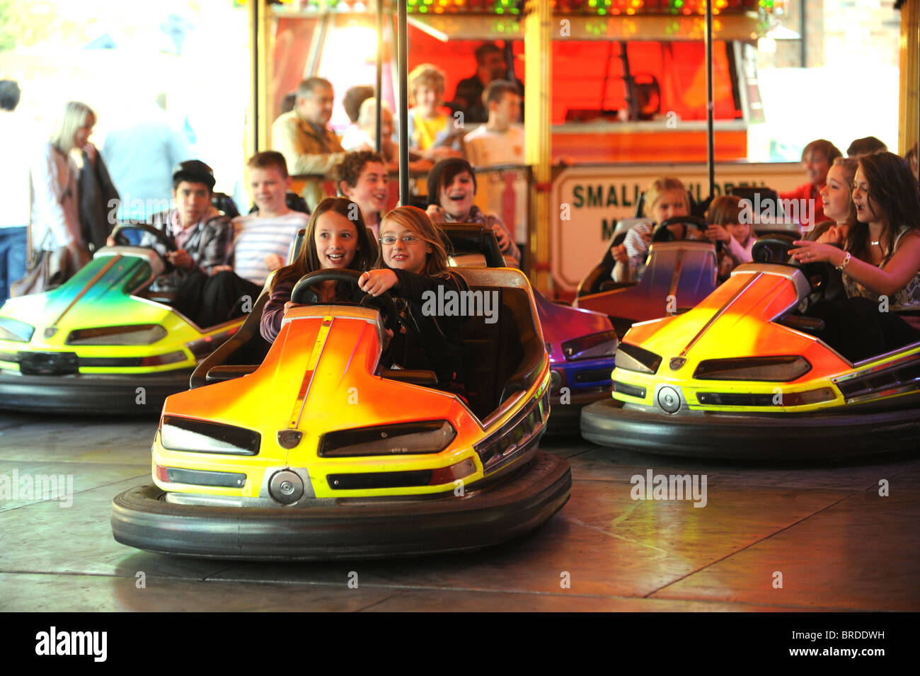 Young girls having on fairground bumper cars. children kids enjoying ...