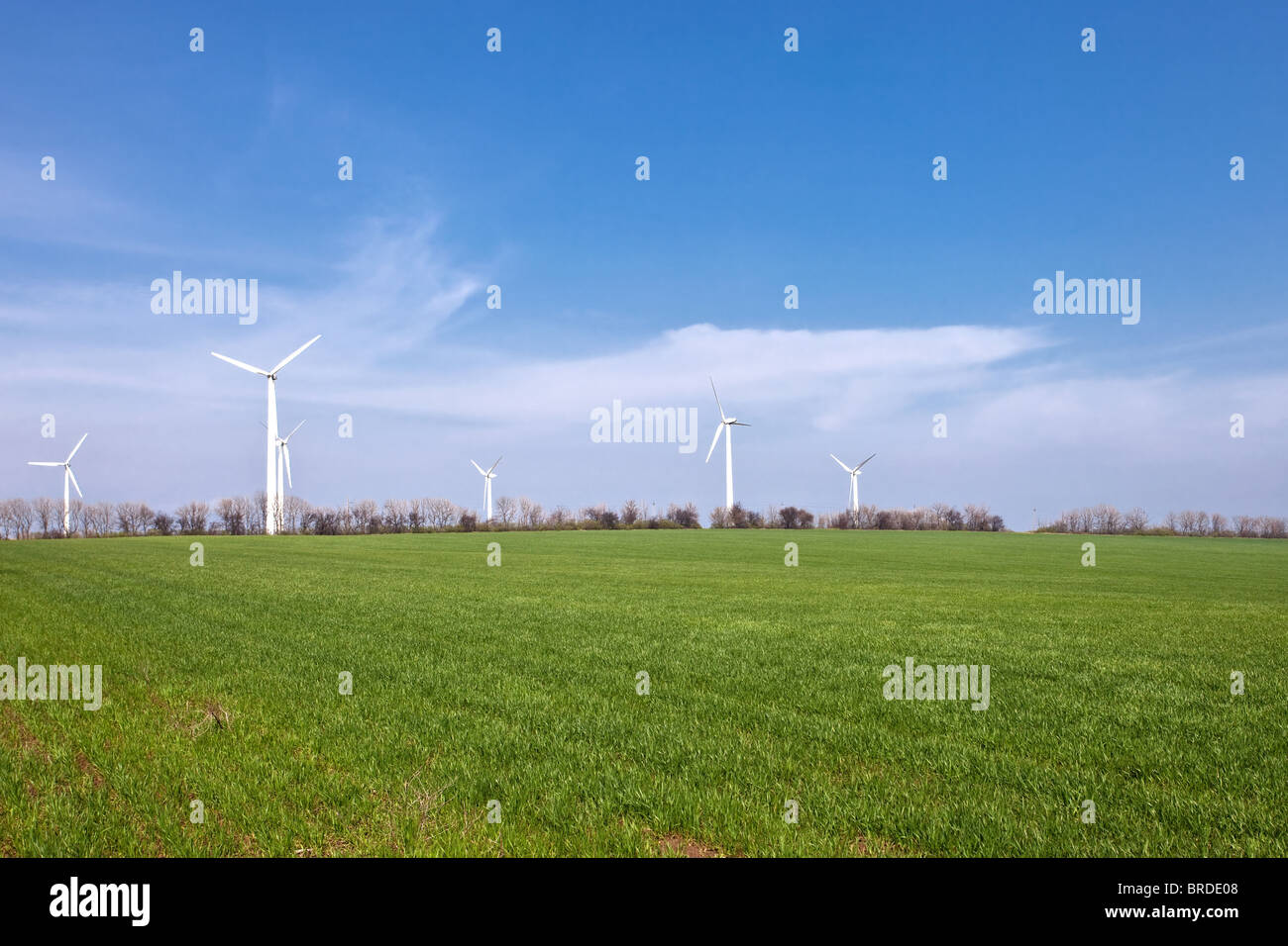 green field with wind energy turbine power Stock Photo - Alamy