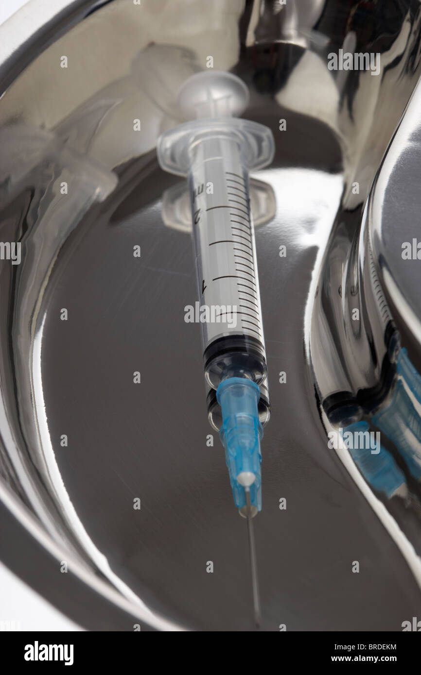 hypodermic syringe and needle in a metal kidney tray Stock Photo - Alamy