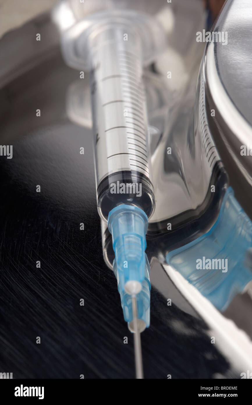 hypodermic syringe and needle in a metal kidney tray Stock Photo - Alamy