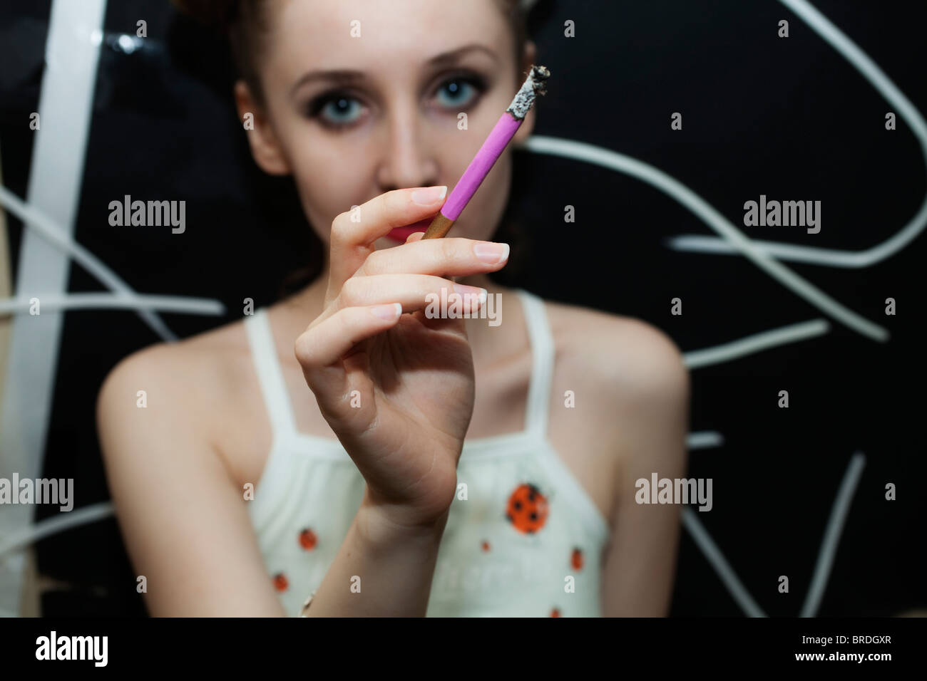 A woman with a pink cigarette in hand Stock Photo - Alamy