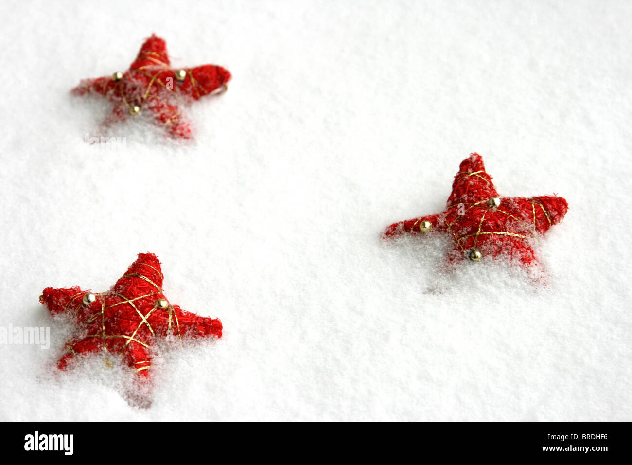 Red Christmas stars on the snow Stock Photo - Alamy