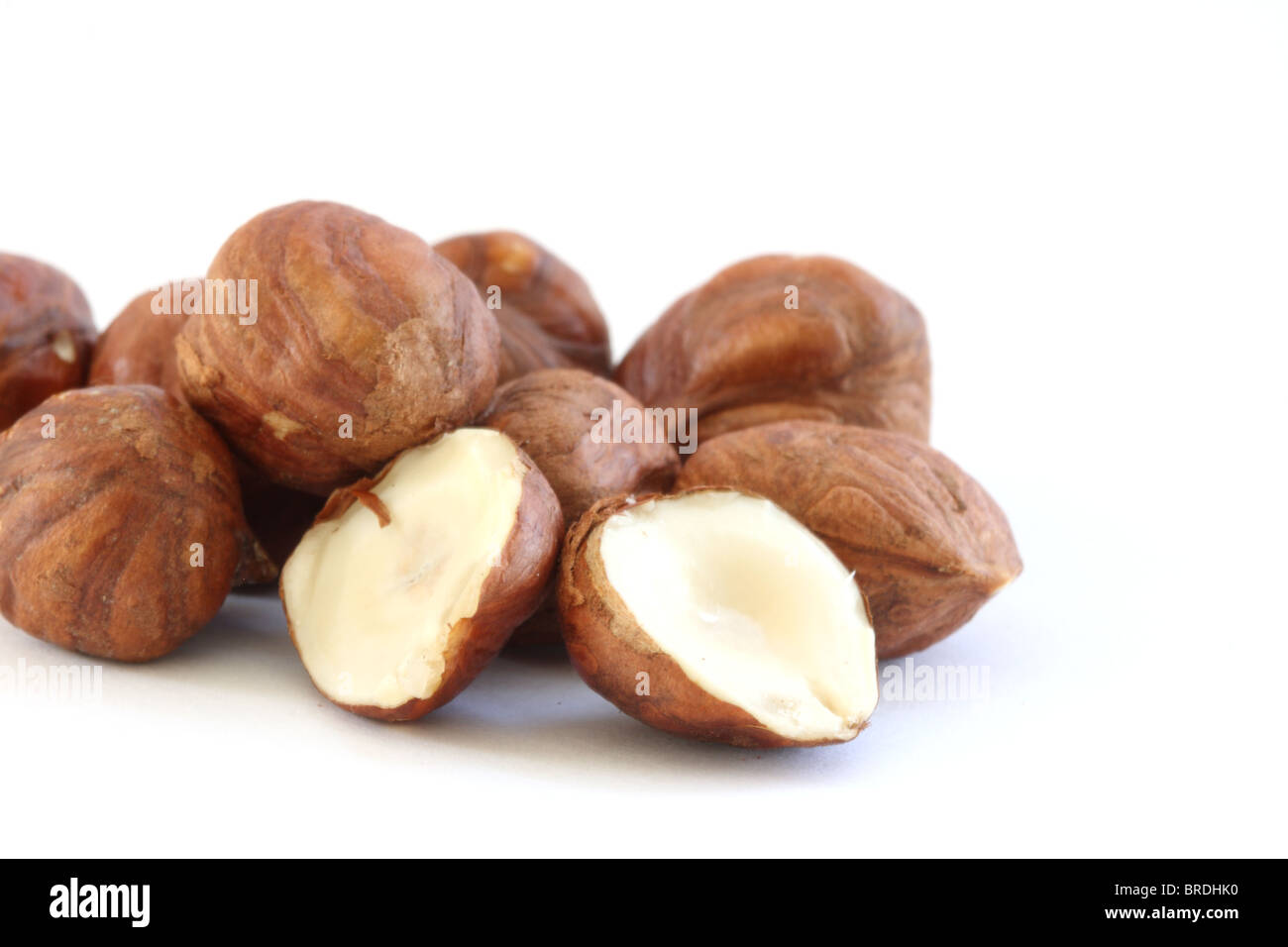 Several peeled hazelnuts and their halfs on white background Stock ...