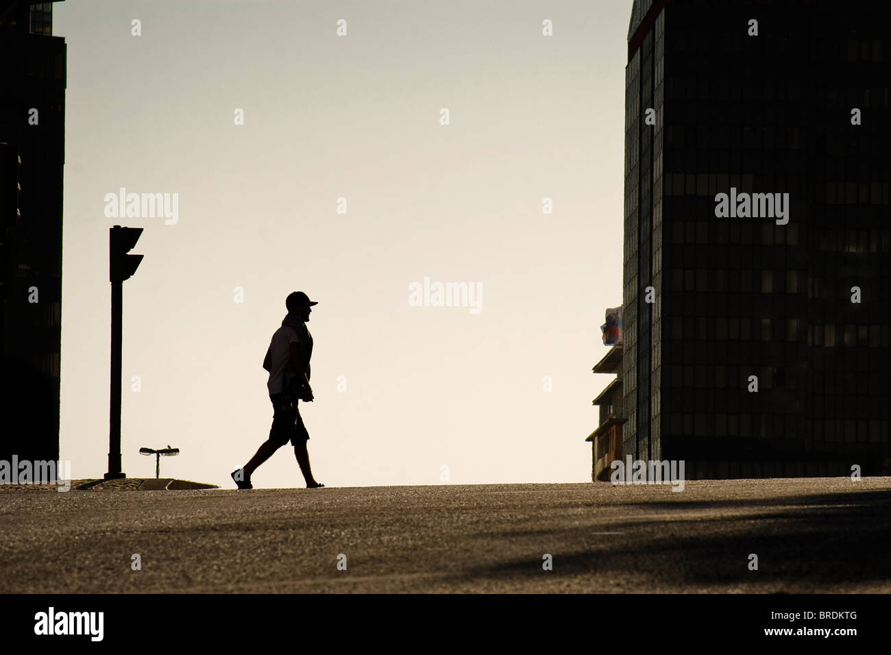 A young man walking with cityscape on the background Stock Photo - Alamy