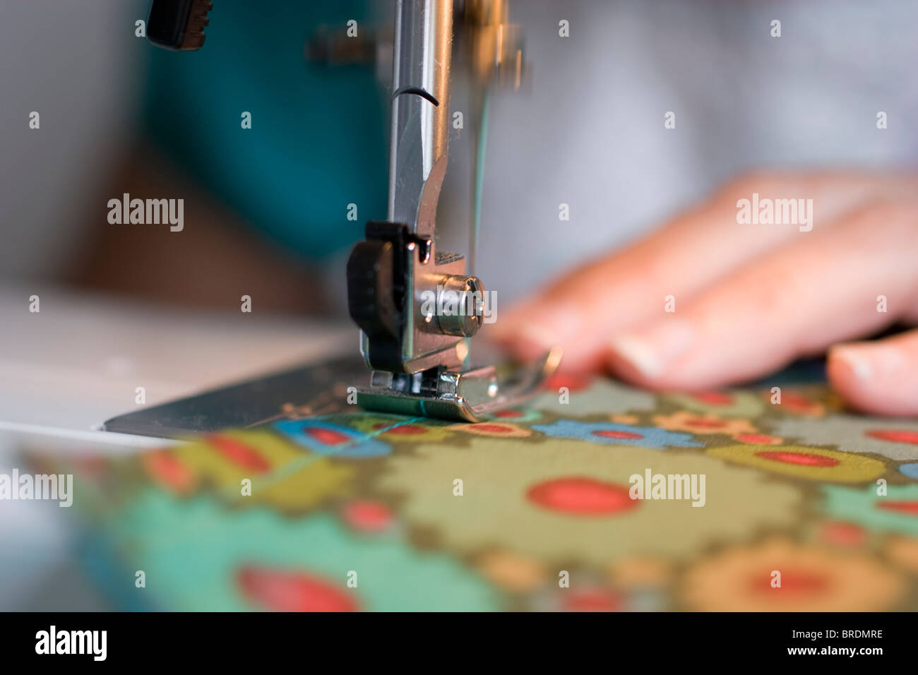 Close up of Seamstress focused at work, skillfully sewing fabric on a ...