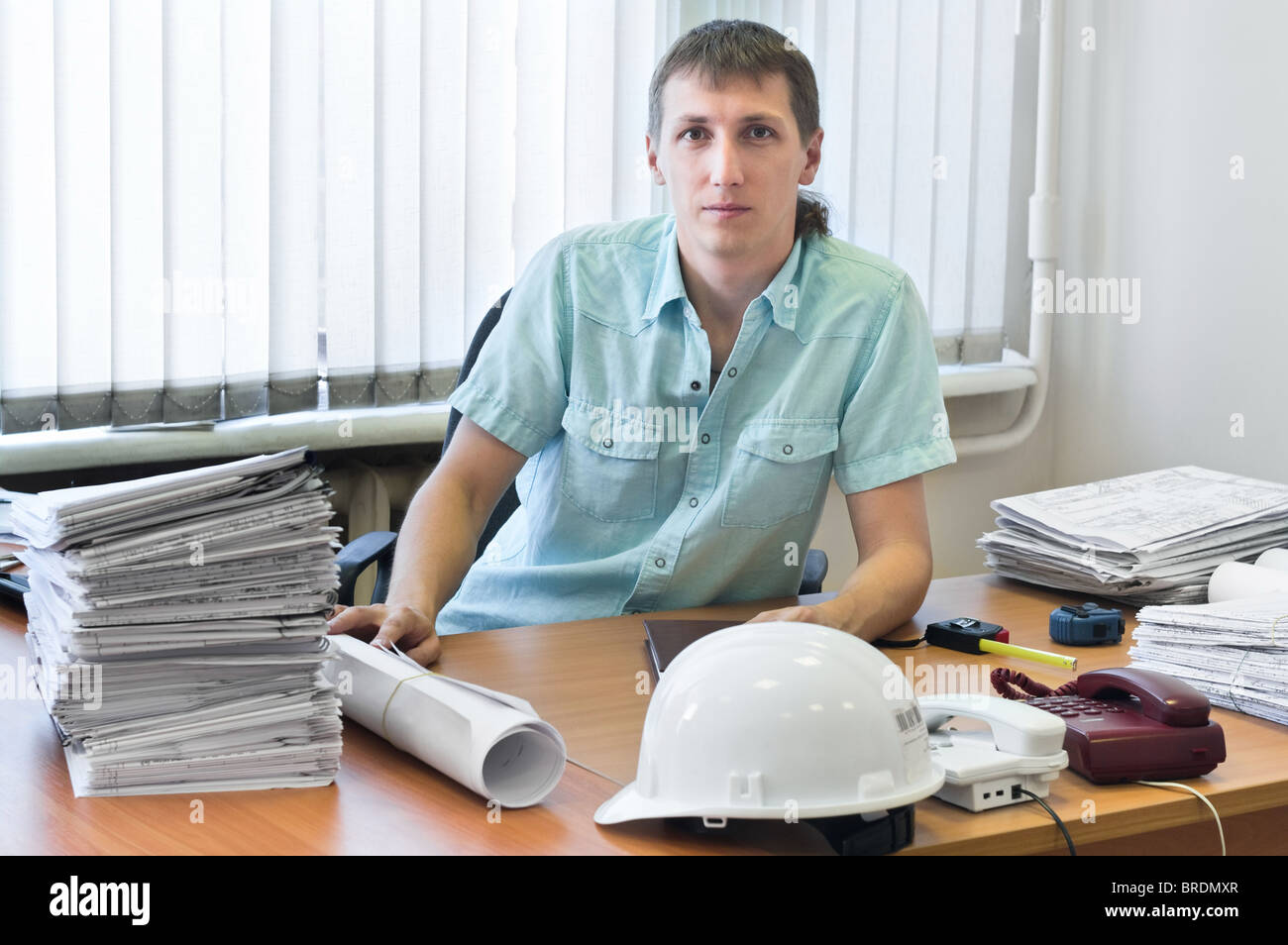 Engineer young adult male with project drawings in office. Working ...