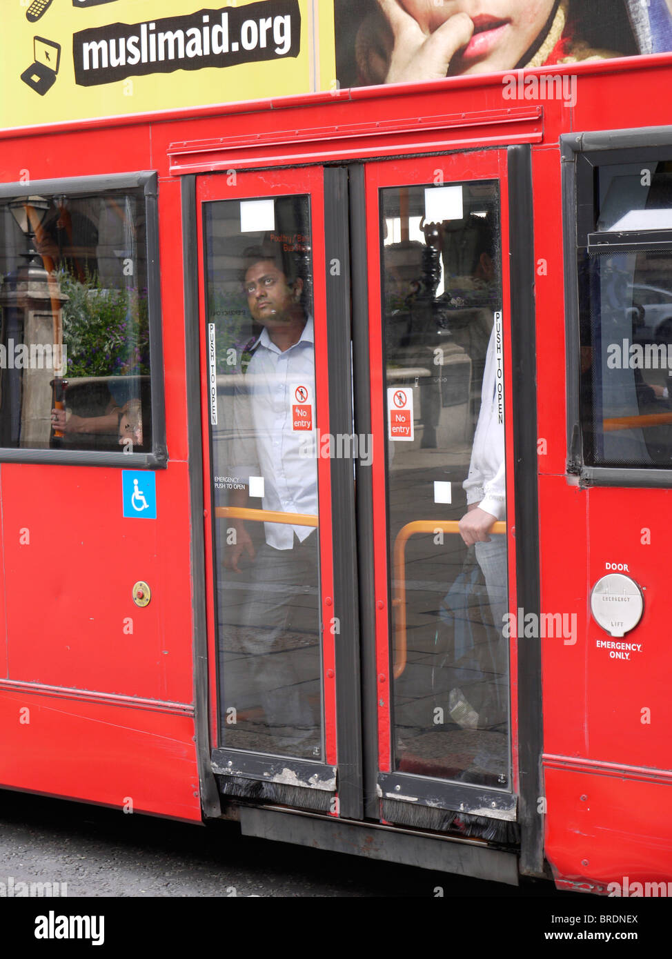Packed London double-decker red bus navigating through rush hour with ...