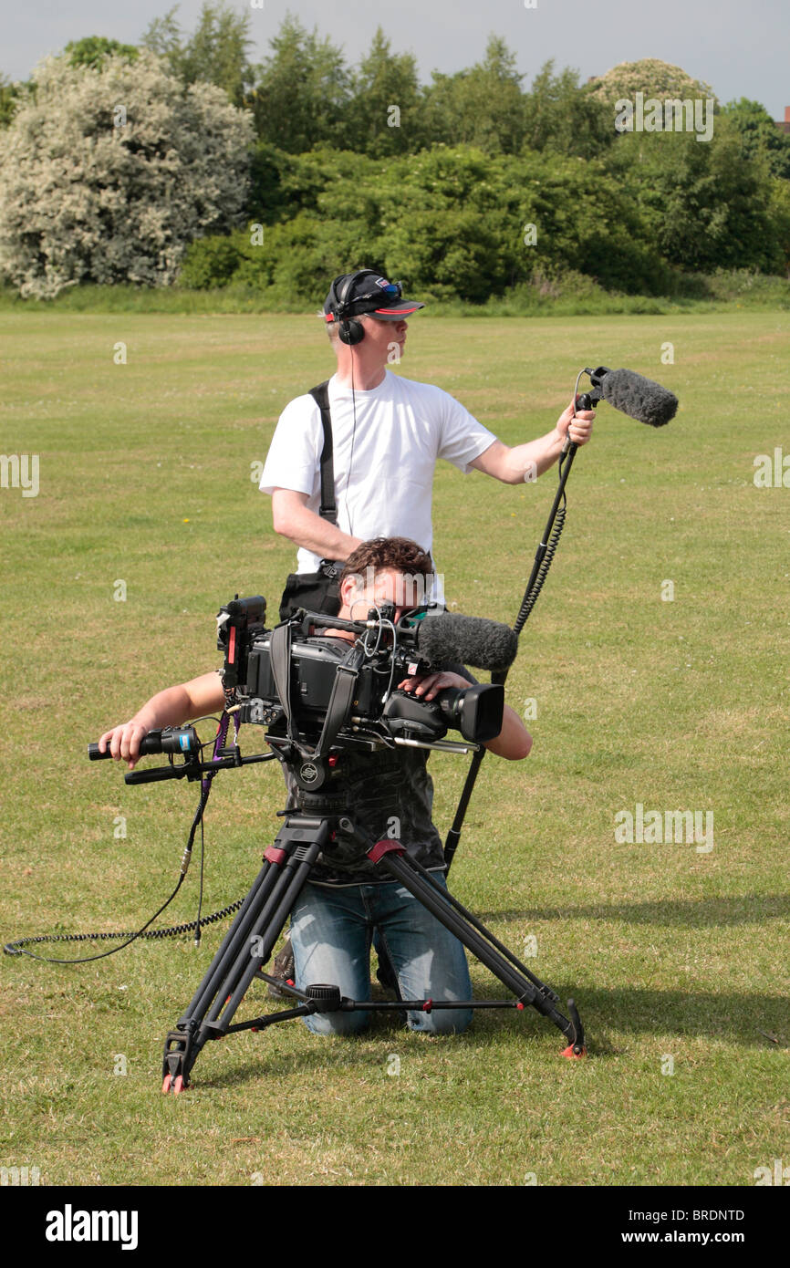 A television film crew (cameraman and sound man) working in a public ...