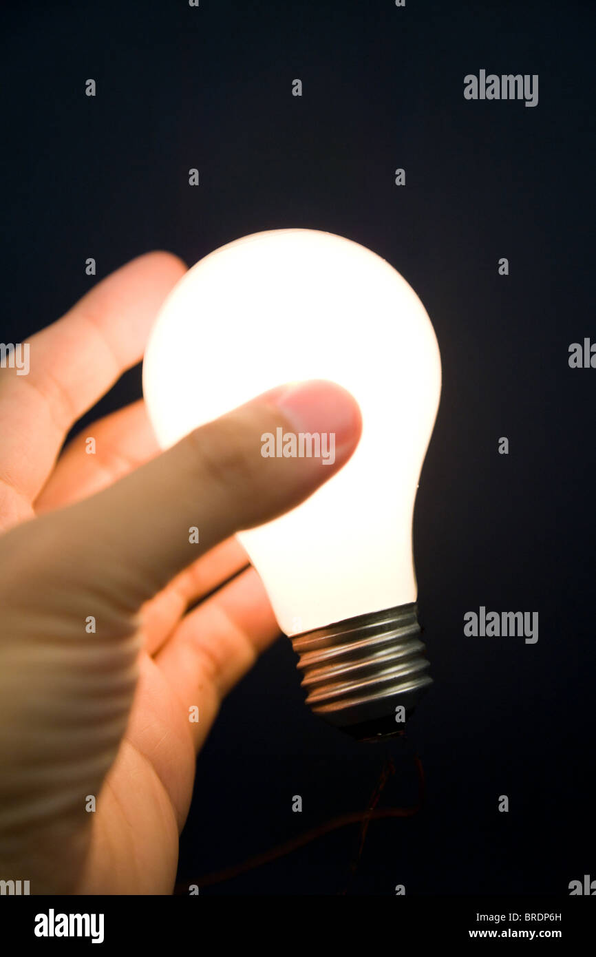 Hand holding a Bright Light Bulb, Concept of Inspiration, Ideas Stock ...