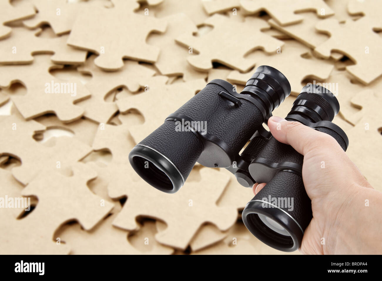 Binoculars and Puzzle, concept of searching Stock Photo - Alamy