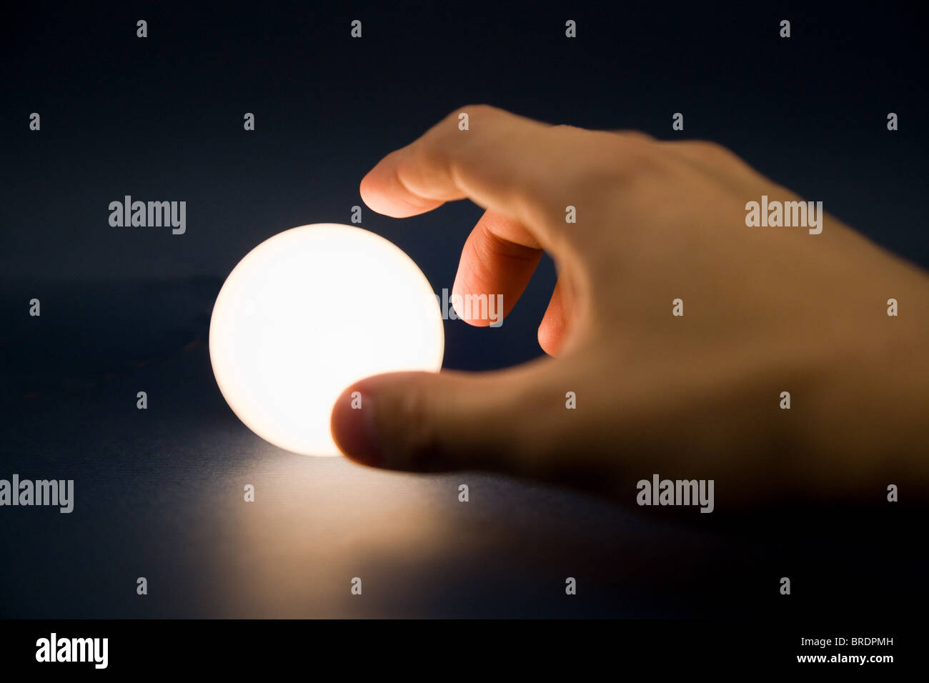 Hand touching a bright ball, Concept of magic Stock Photo - Alamy