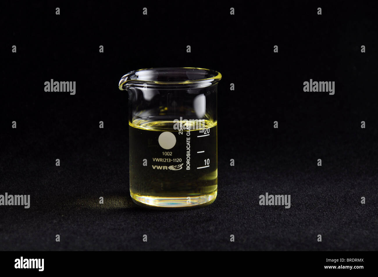 Clear glass measuring beaker 25ml containing carrier oils on Black ...
