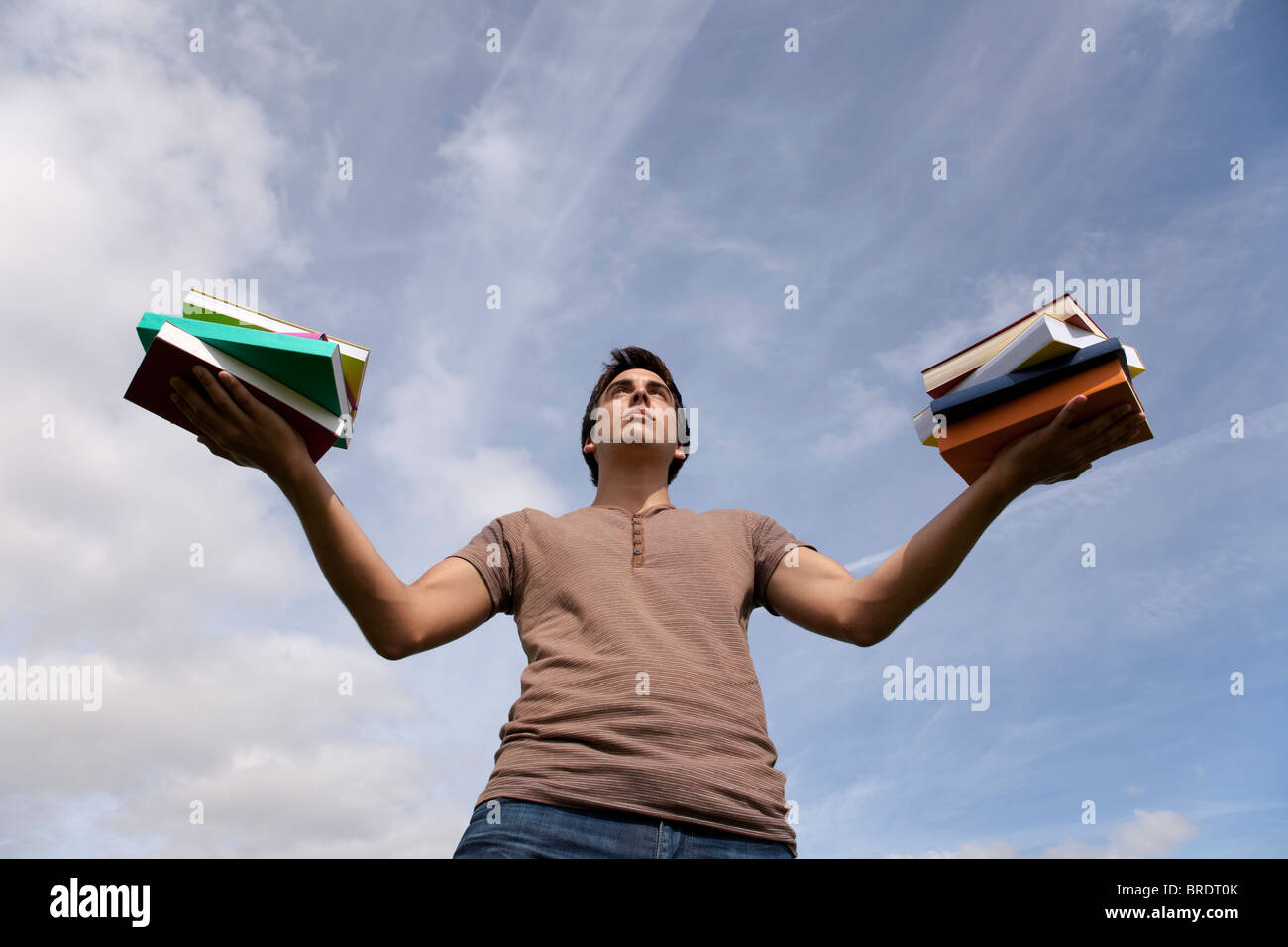 Young men holding school books and looking away Stock Photo - Alamy