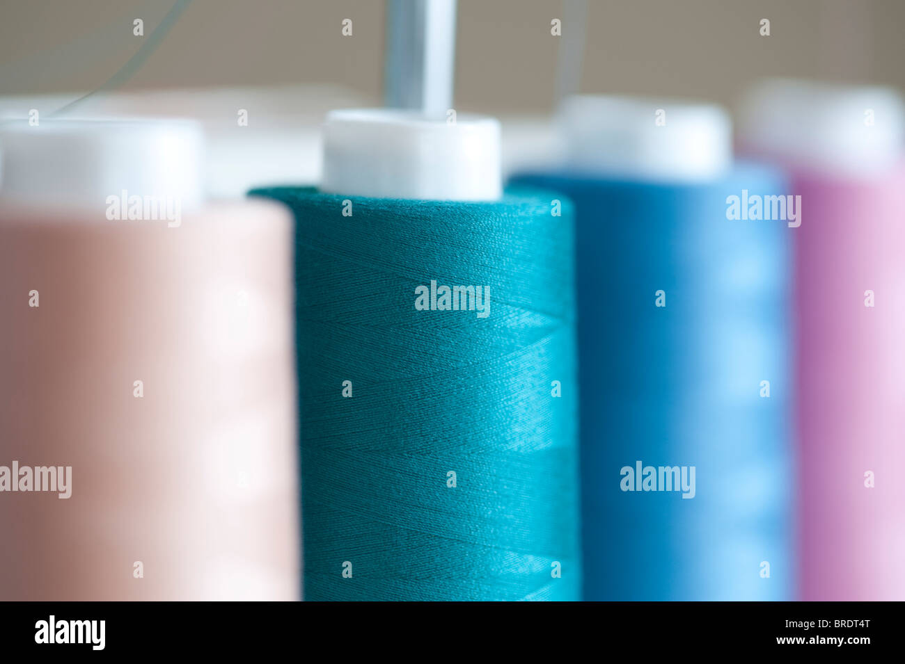 Multicolored spools of thread on a spindle on a serger sewing machine ...