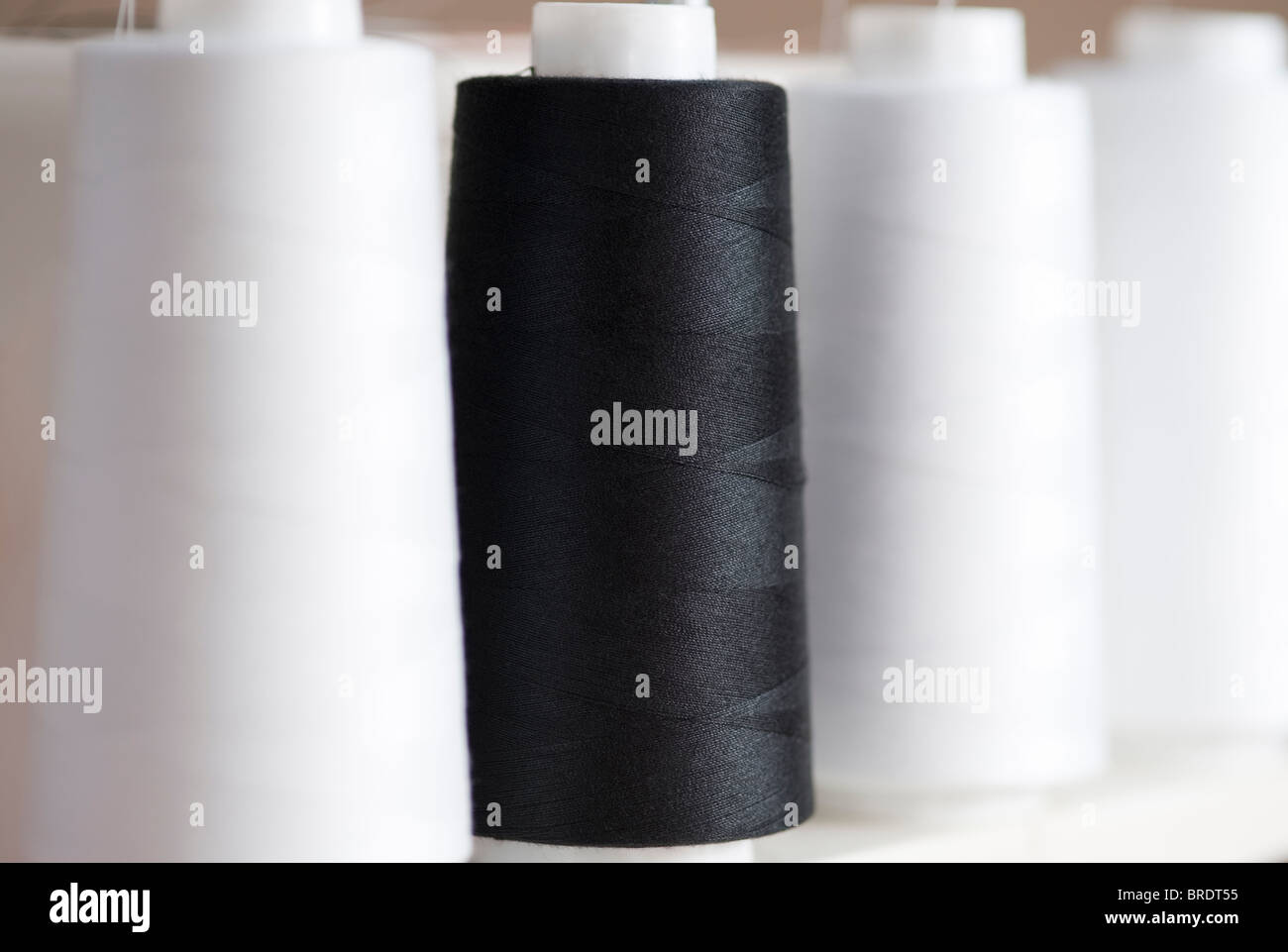 Black and white spools of thread on a serger sewing machine Stock Photo ...