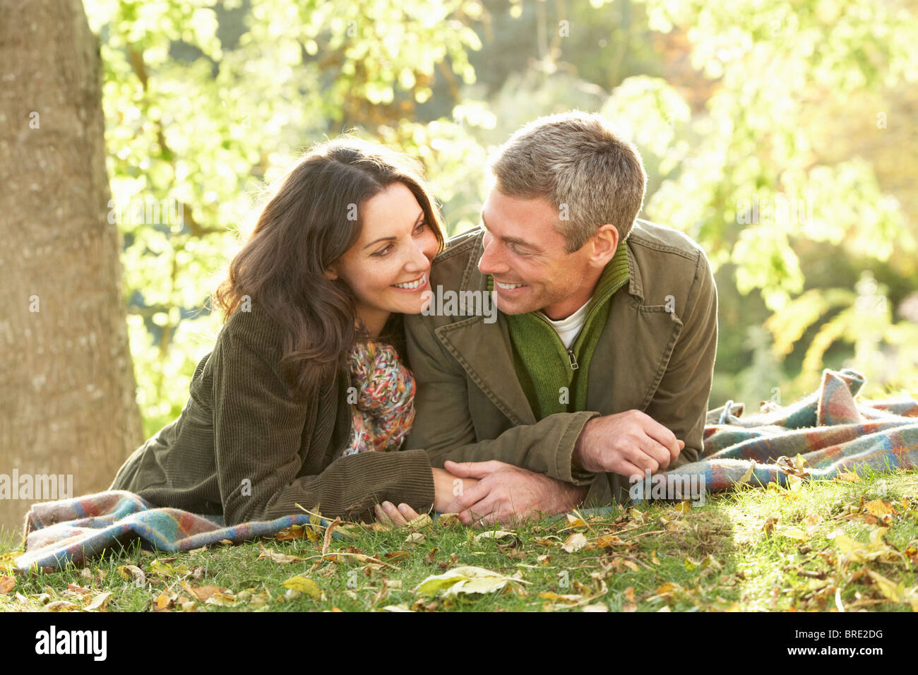 Romantic Couple Relaxing Outdoors In Autumn Landscape Stock Photo - Alamy