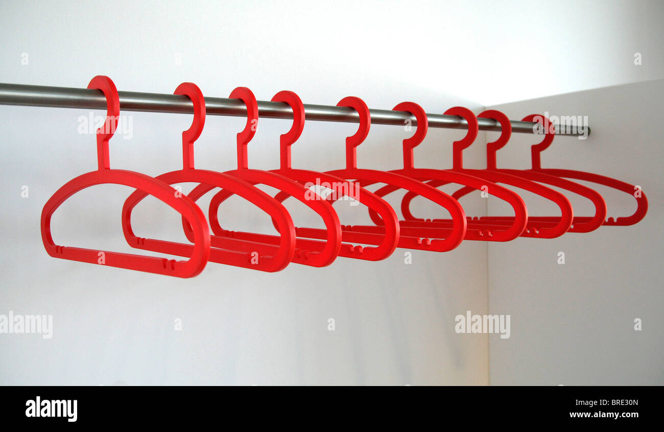 Red clothes hangers on a hanging rail Stock Photo - Alamy