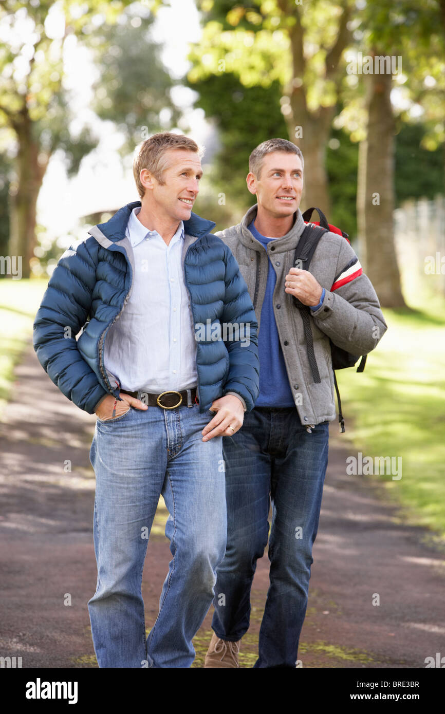 Two Male Friends Walking Outdoors In Autumn Park Together Stock Photo ...