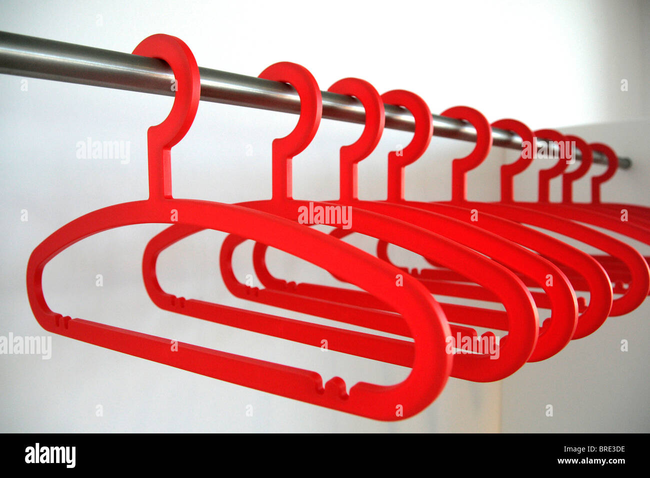 Red clothes hangers on a hanging rail Stock Photo - Alamy
