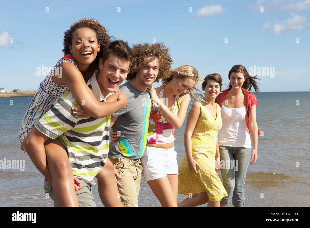 Group Of Young Friends Walking Along Summer Shoreline Stock Photo - Alamy