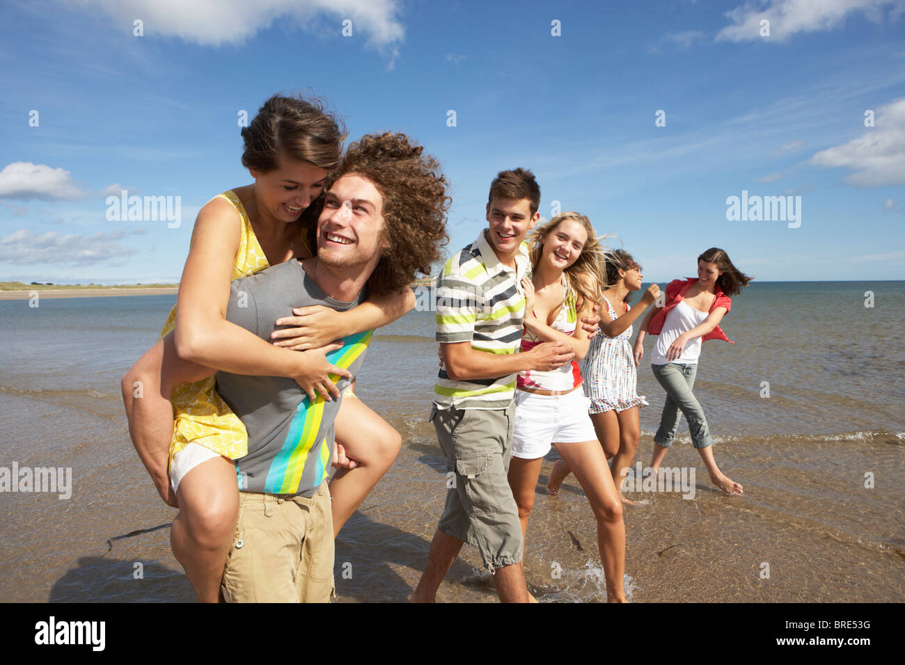 Group Of Young Friends Walking Along Summer Shoreline Stock Photo - Alamy