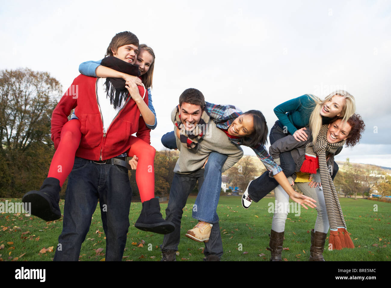 Group Of Teenage Friends Having Piggyback Rides In Autumn Landscape ...