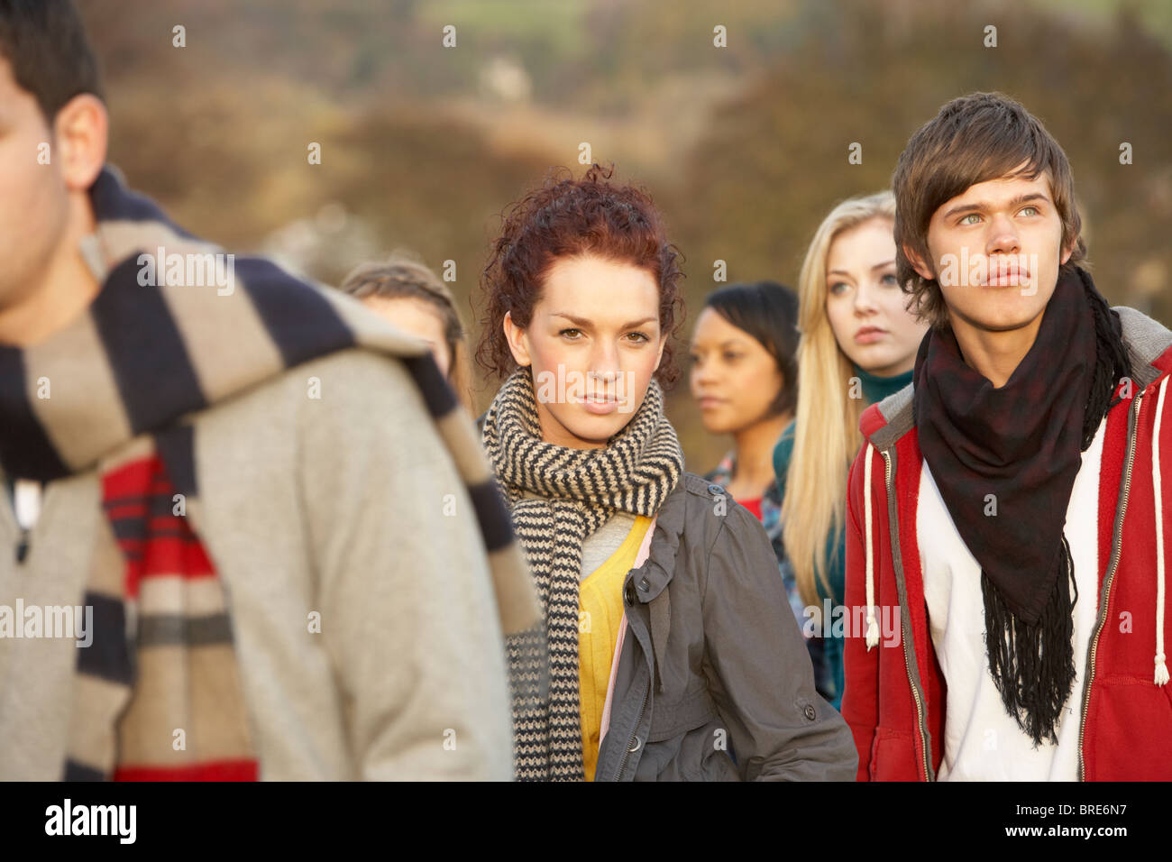 Teenage Girl Surrounded By Friends In Outdoor Autumn Landscape Stock ...