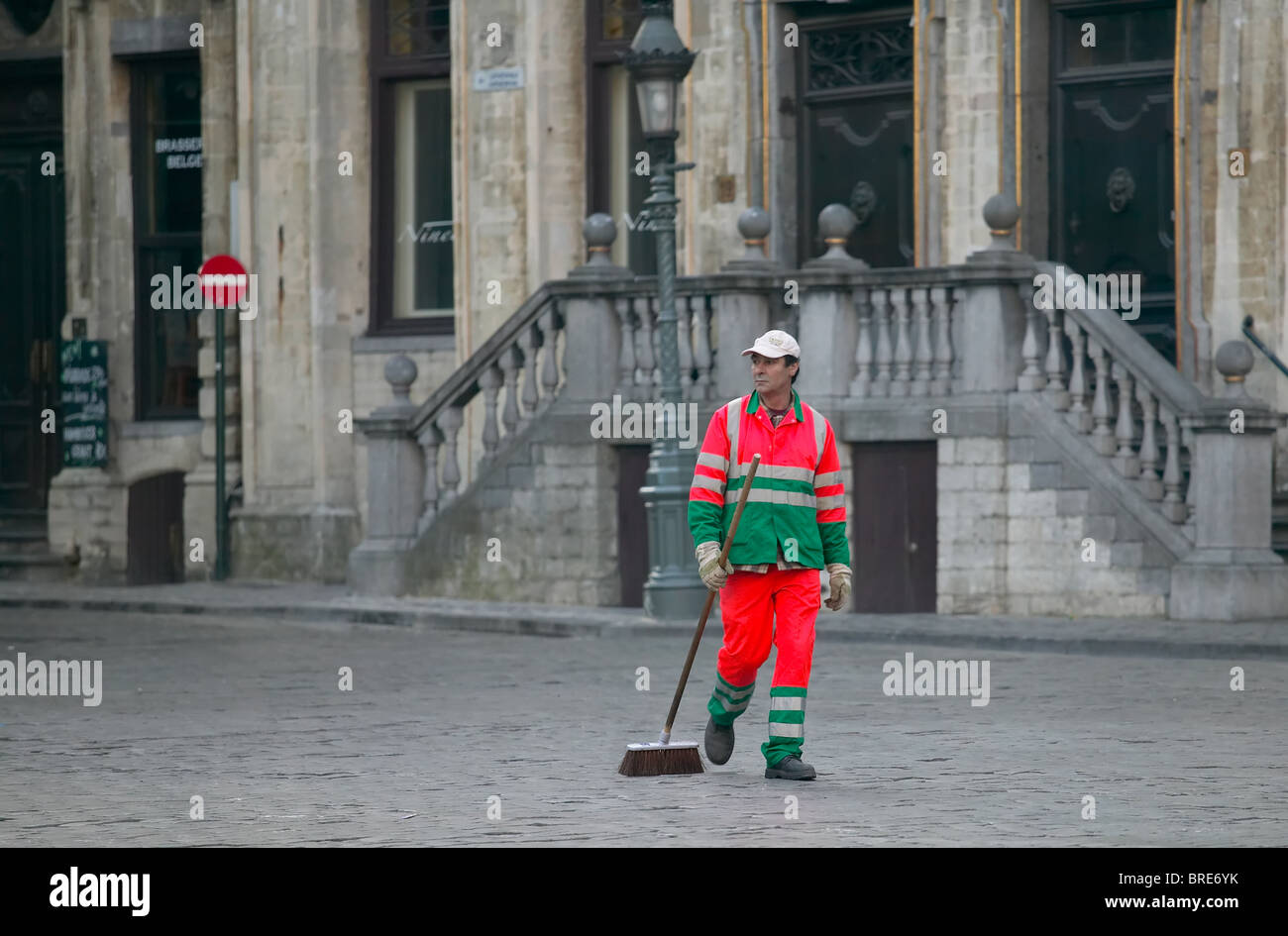 An orange-clad street sweeper cleans in Grand Place, Brussels, Belgium ...
