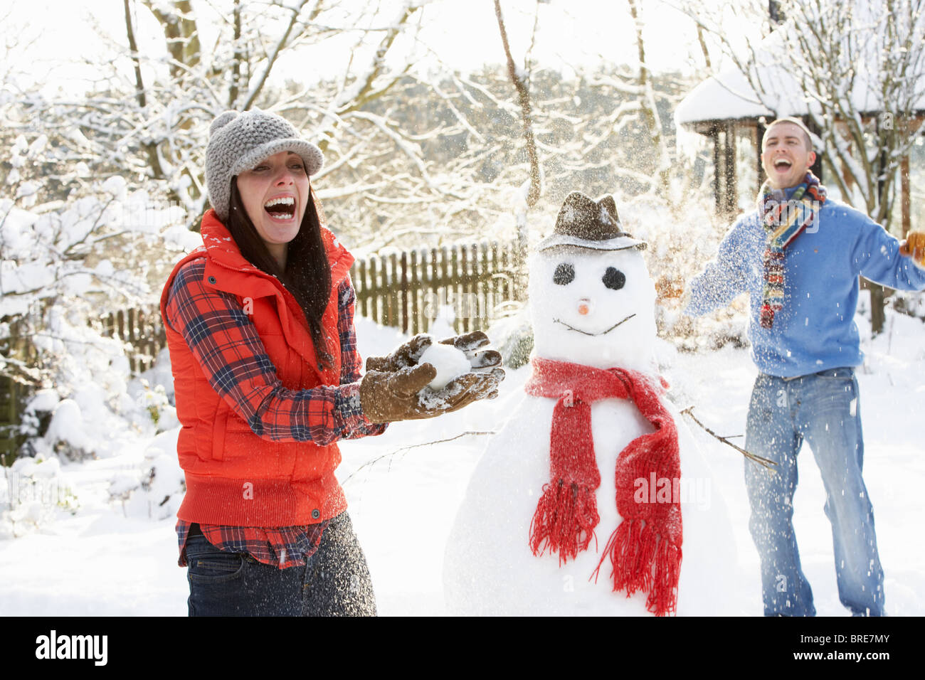 Young Couple Having Snowball Fight In Garden Stock Photo - Alamy